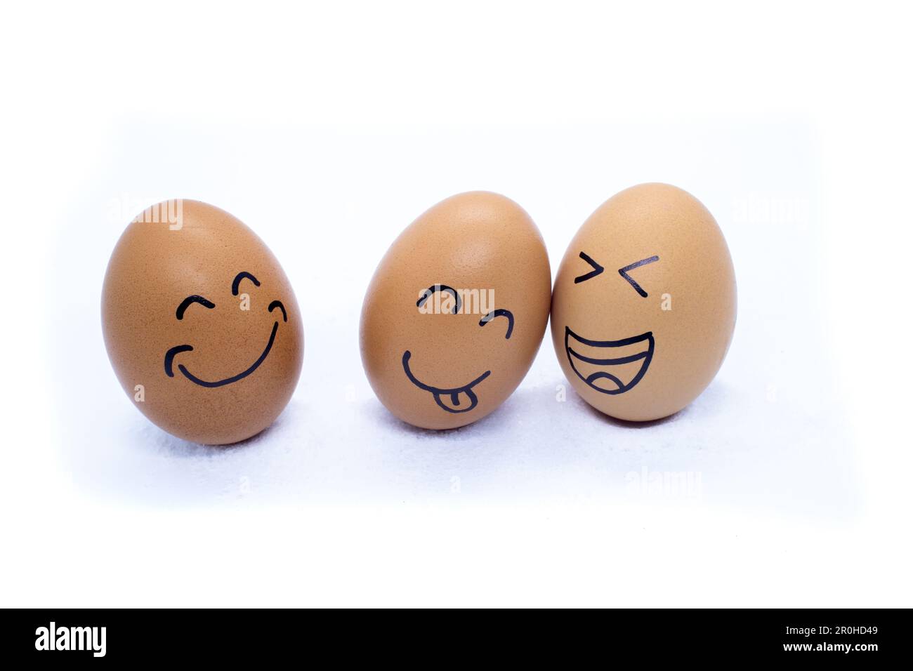 A collection of multicolored eggs with human facial features drawn upon ...