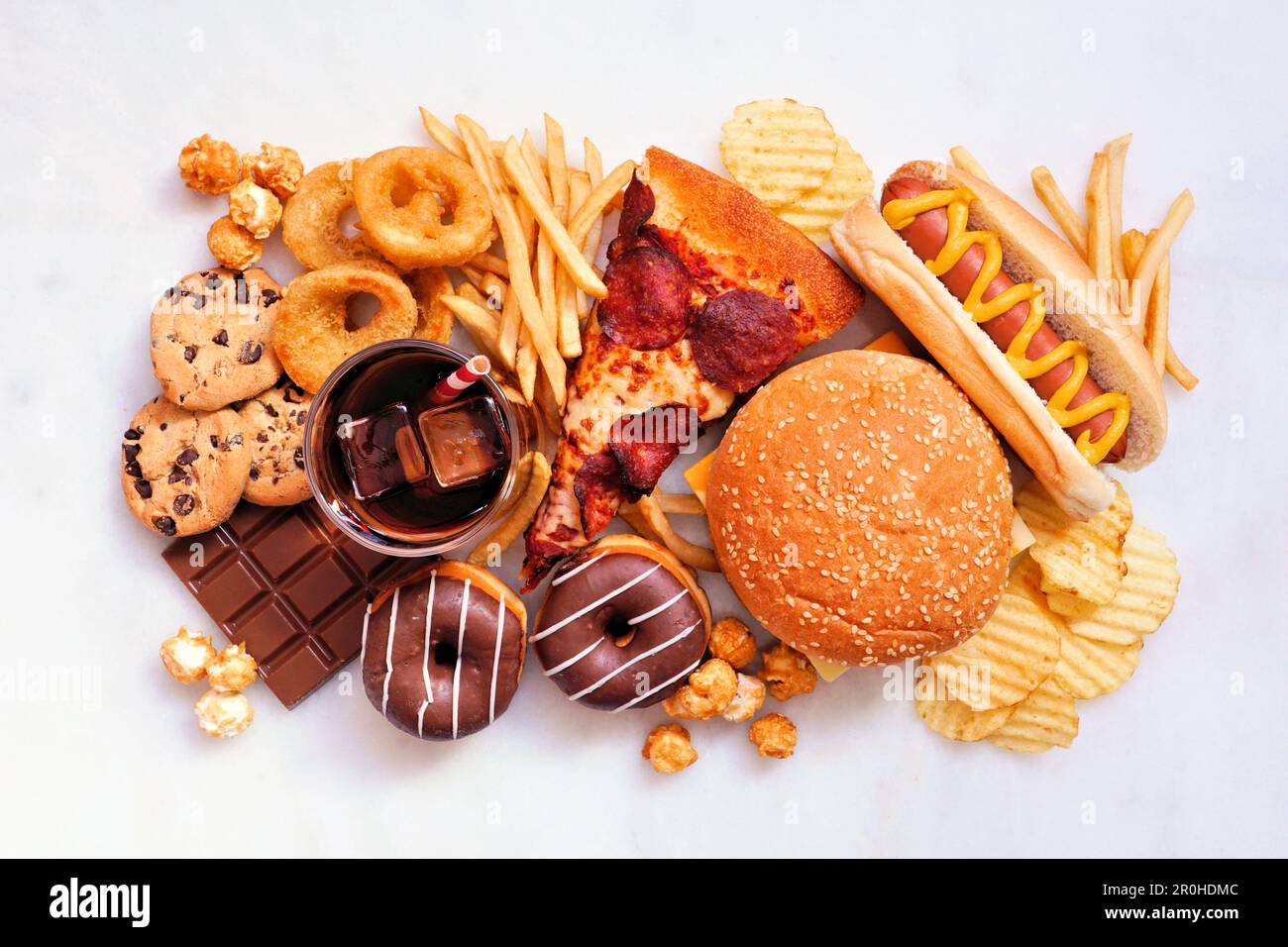 Junk food table scene. Collection scattered over a white marble ...