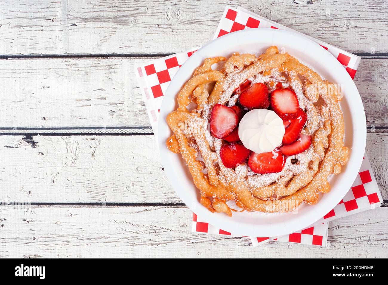 Strawberry funnel cake above view over a white wood background ...