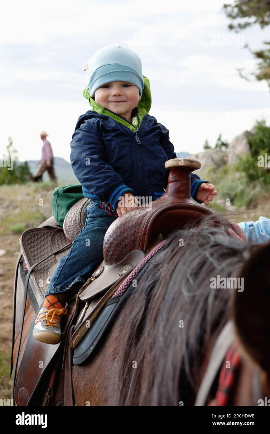 USA, Wyoming, Encampment, a young boy sits on a horse for the first ...