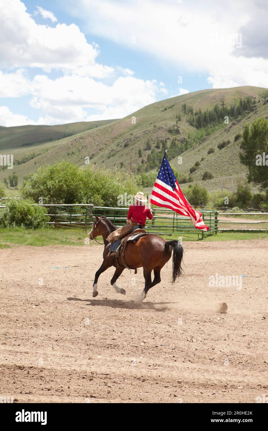 USA, Wyoming, Encampment, a young man rides his horse carrying the ...