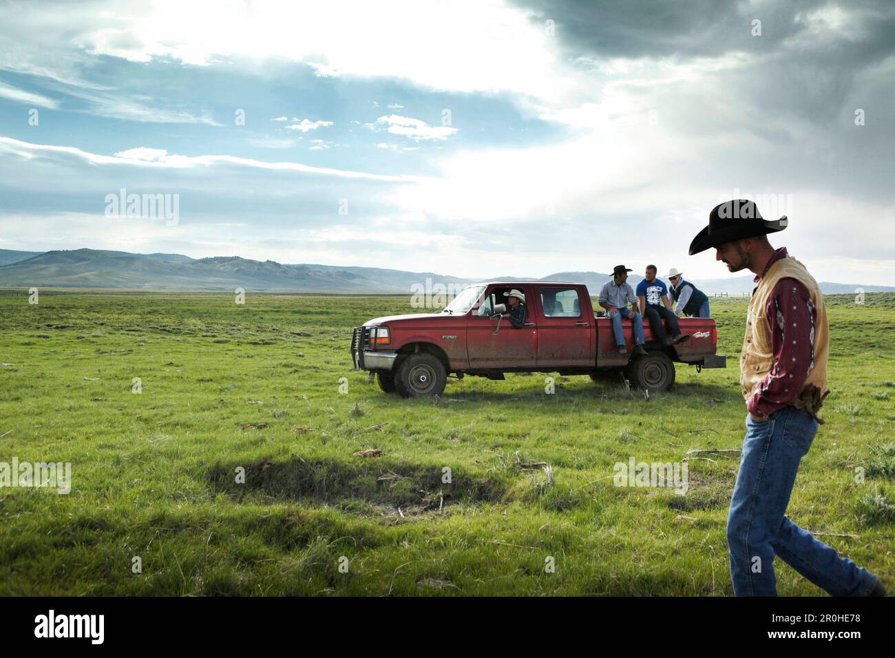 USA, Wyoming, Encampment, ranch hands move towards a corral to begin ...