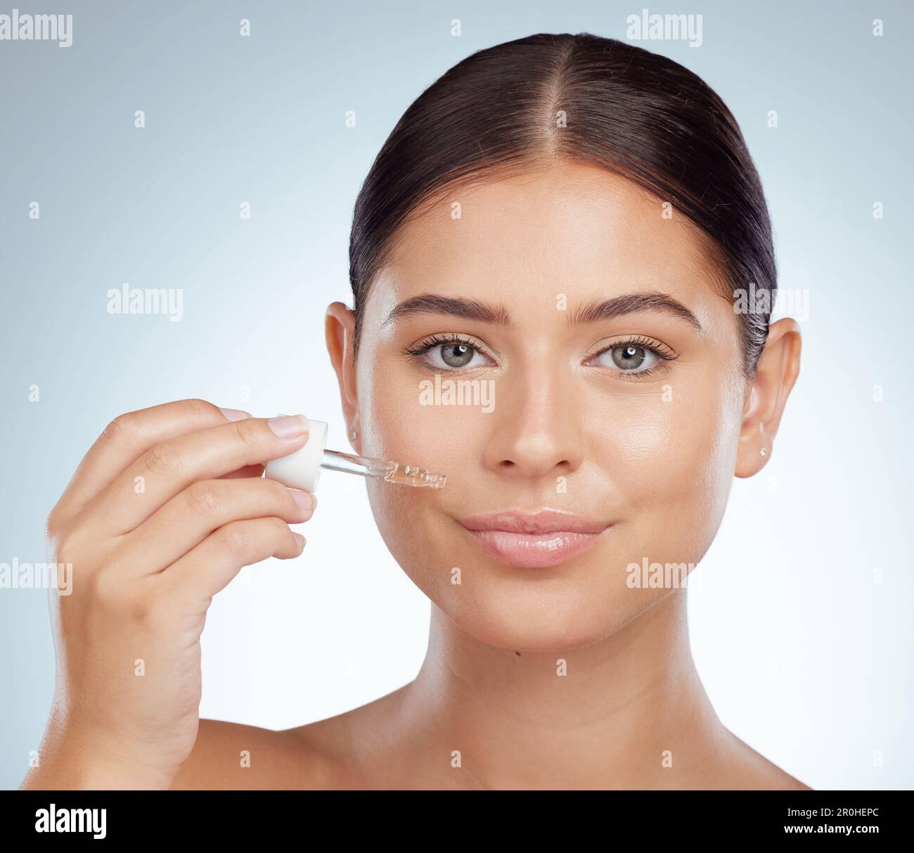 Portrait beautiful woman using dropper to apply face serum to lips with ...