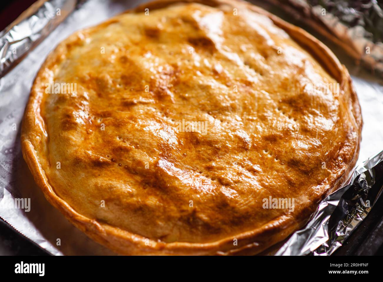 Cooked closed pie. Baked round cake on a baking sheet Stock Photo - Alamy