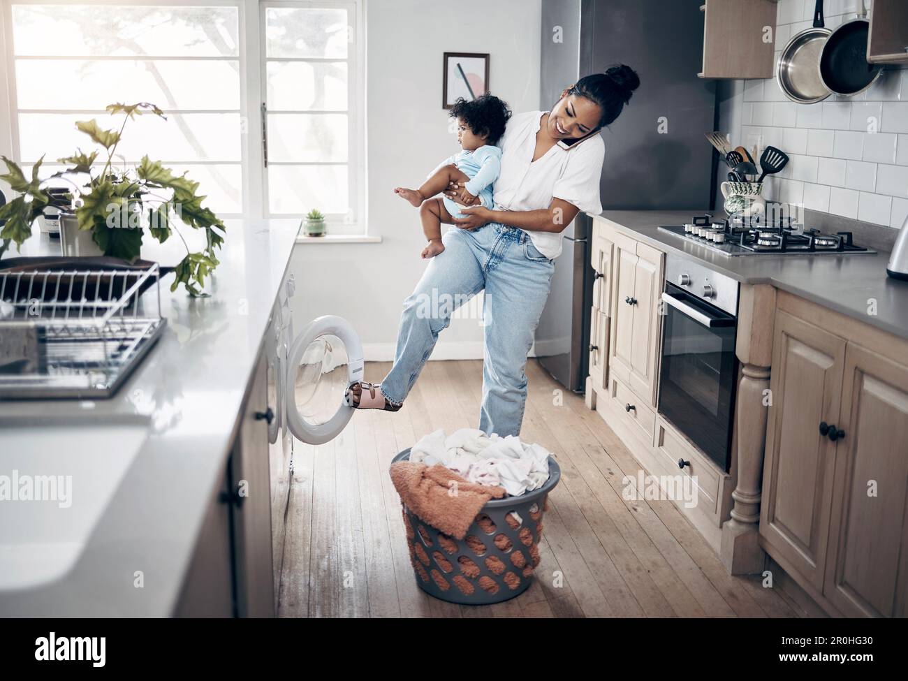 The skills of a working mom. a young mother using a cellphone while ...