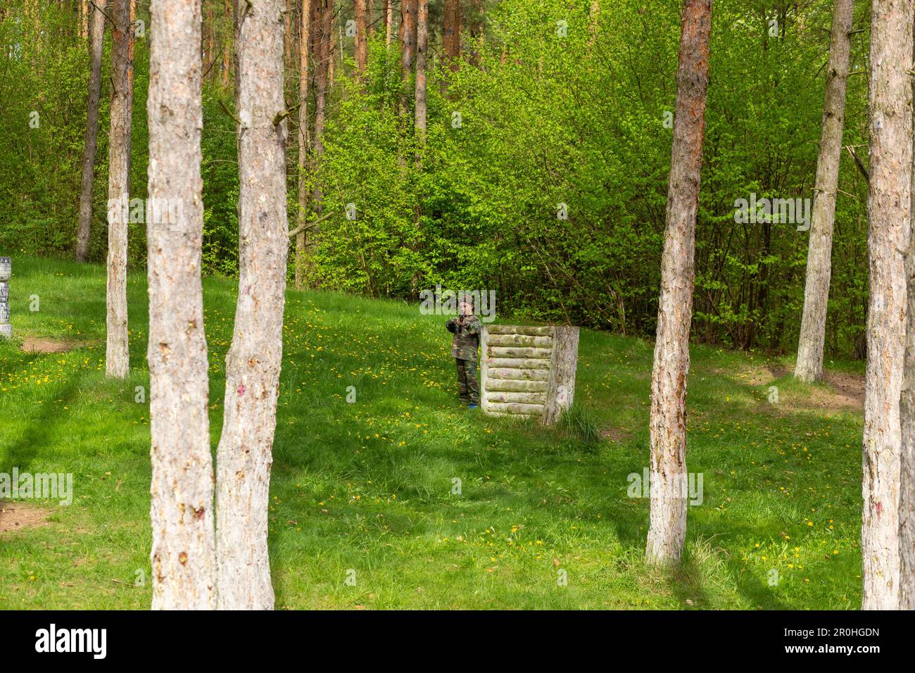Boy weared in camouflage playing laser tag in special forest playground ...