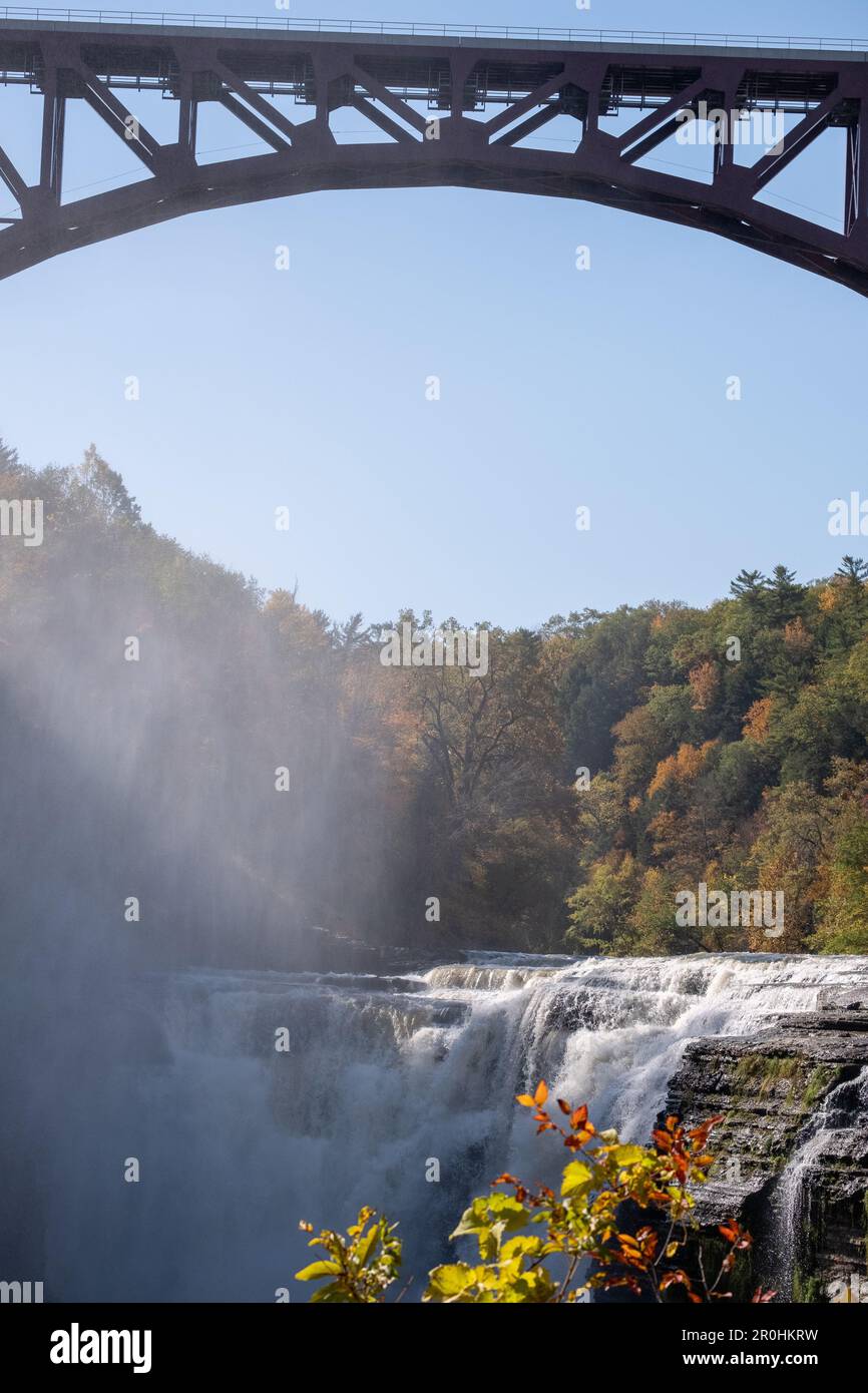 A scenic view of a railroad bridge traversing a majestic waterfall in ...