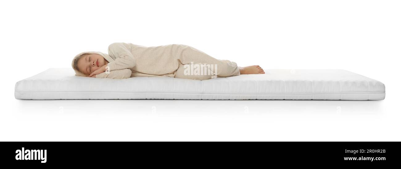 Little girl sleeping on comfortable mattress against white background ...