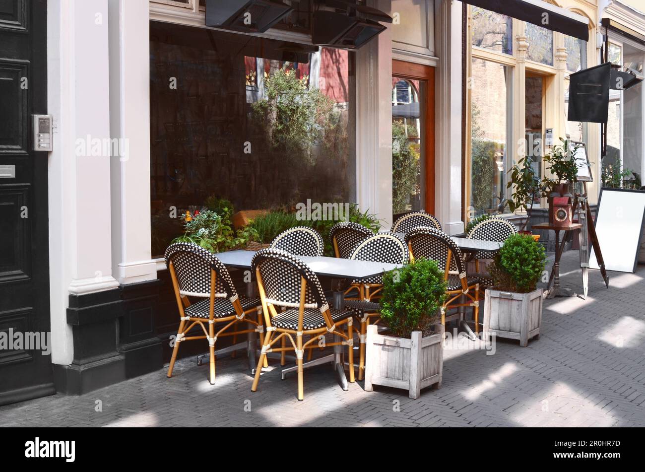 Chairs and tables near cafe on city street Stock Photo - Alamy