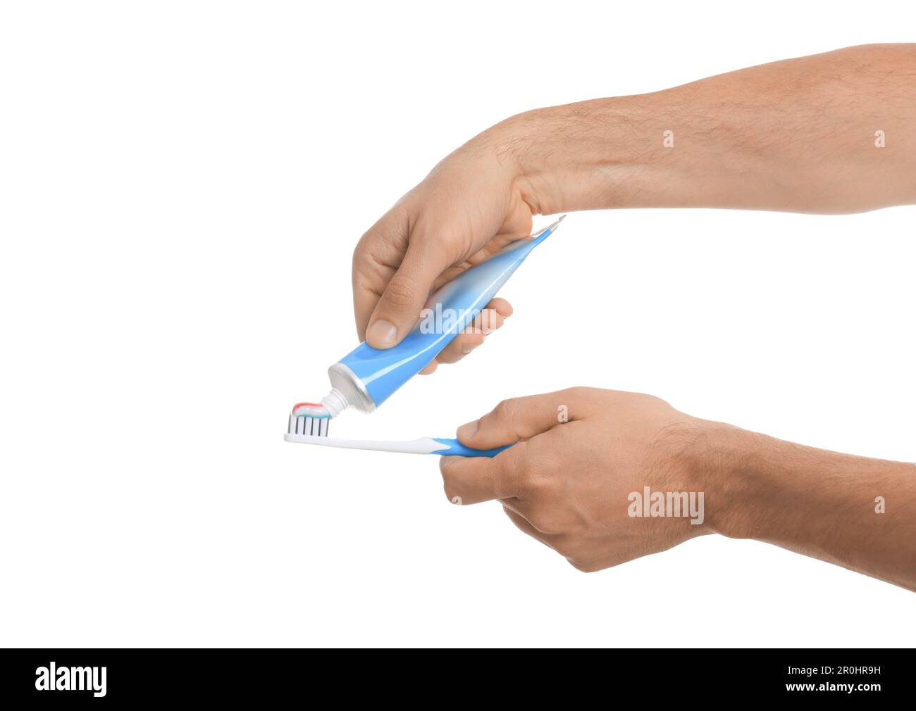 Man applying toothpaste on brush against white background, closeup ...