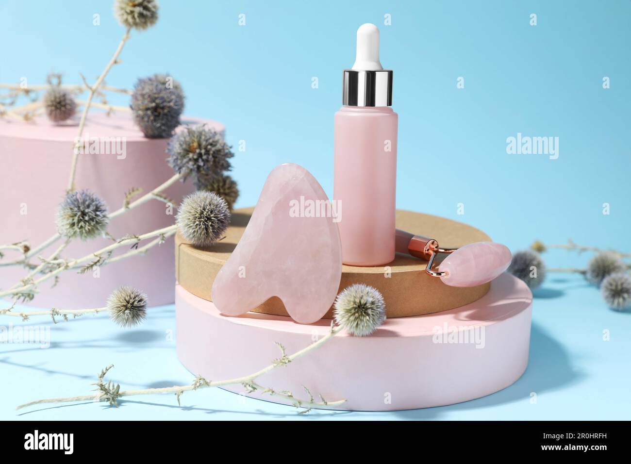 Beautiful composition with gua sha stone, face roller and bottle of ...