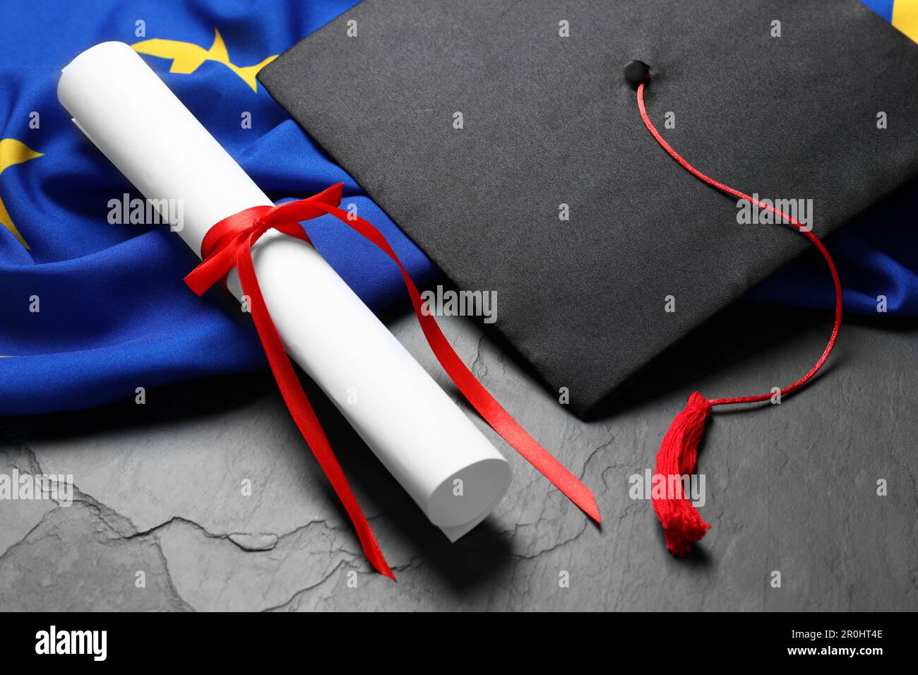 Graduation cap, diploma and flag of European Union on black table Stock ...