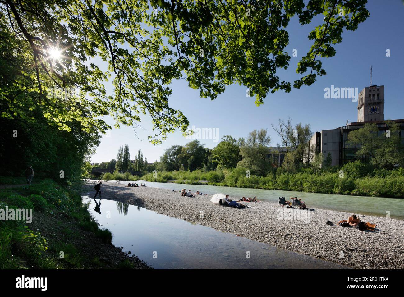 People sunbathing at river Isar, Deutsches Museum in background, Munich ...