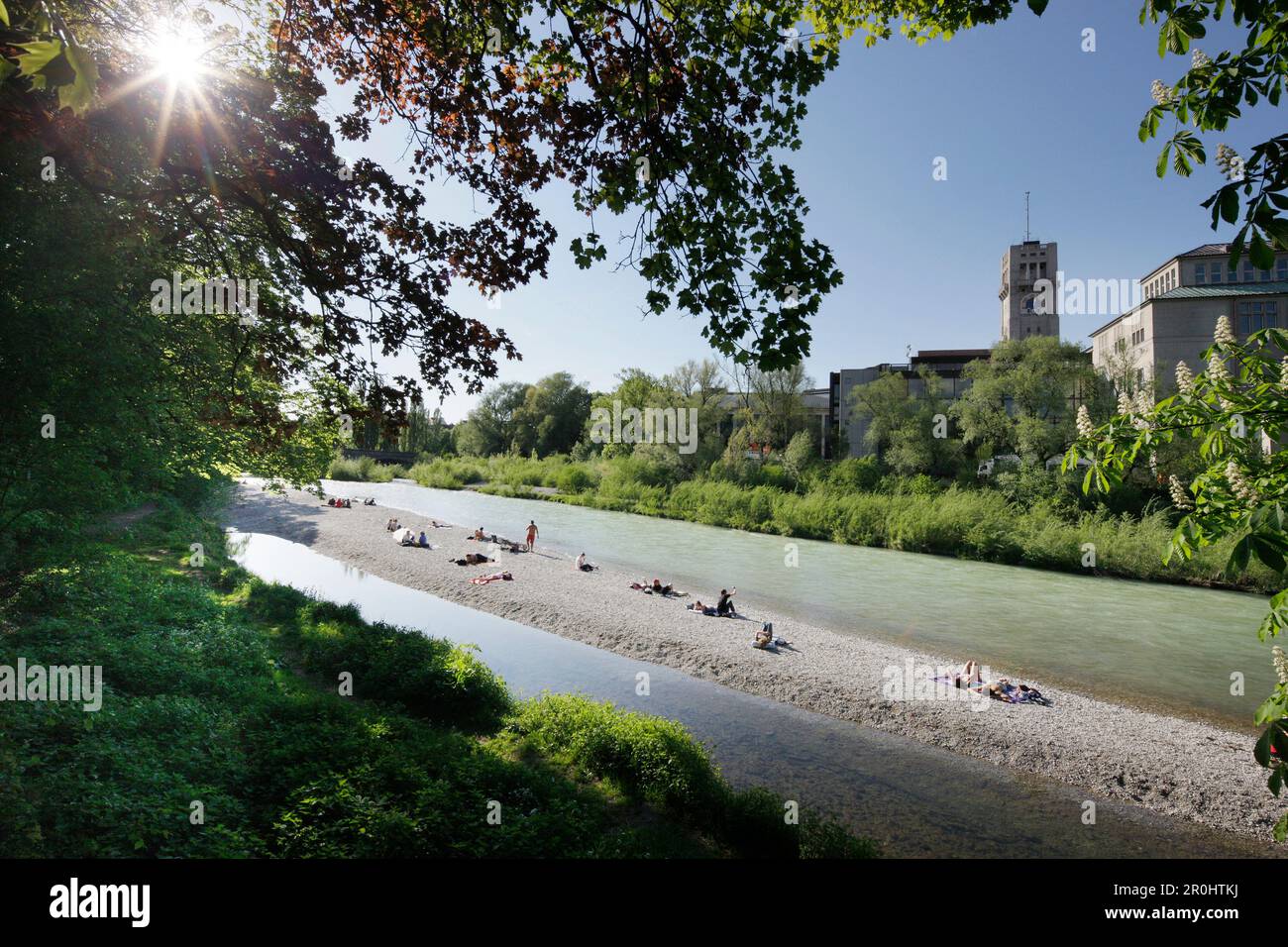 People sunbathing at river Isar, Deutsches Museum in background, Munich ...