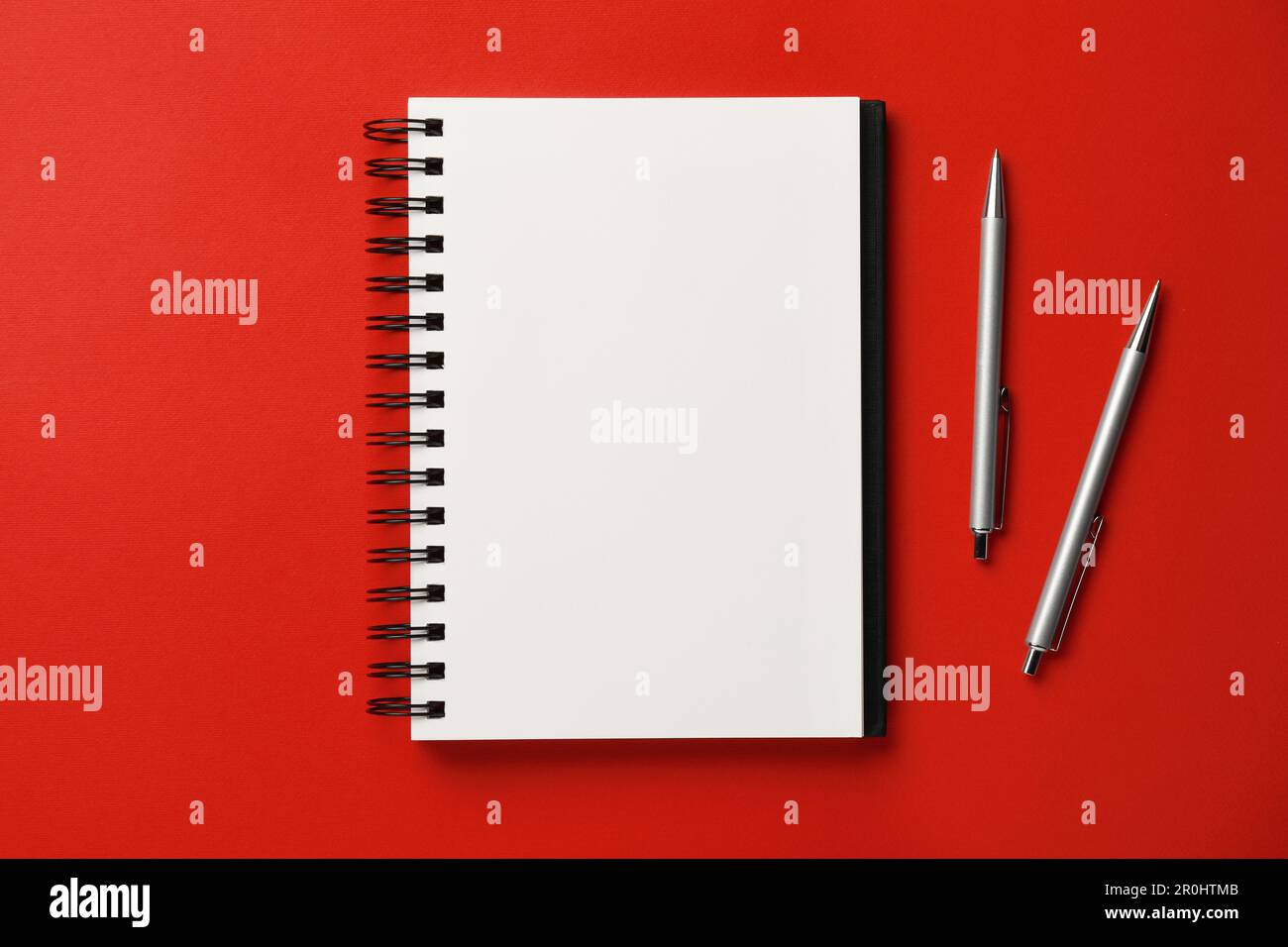Notebook and pens on red background, flat lay Stock Photo - Alamy