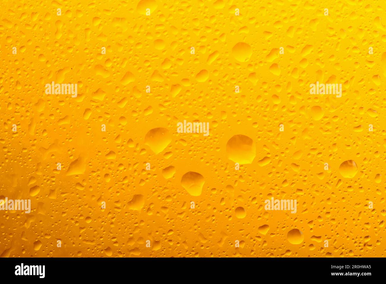 Glass of tasty cold beer with condensation drops as background, closeup ...