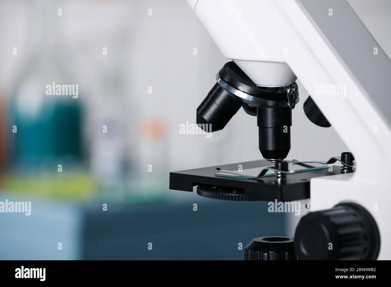 Modern medical microscope with glass slide on blurred background ...