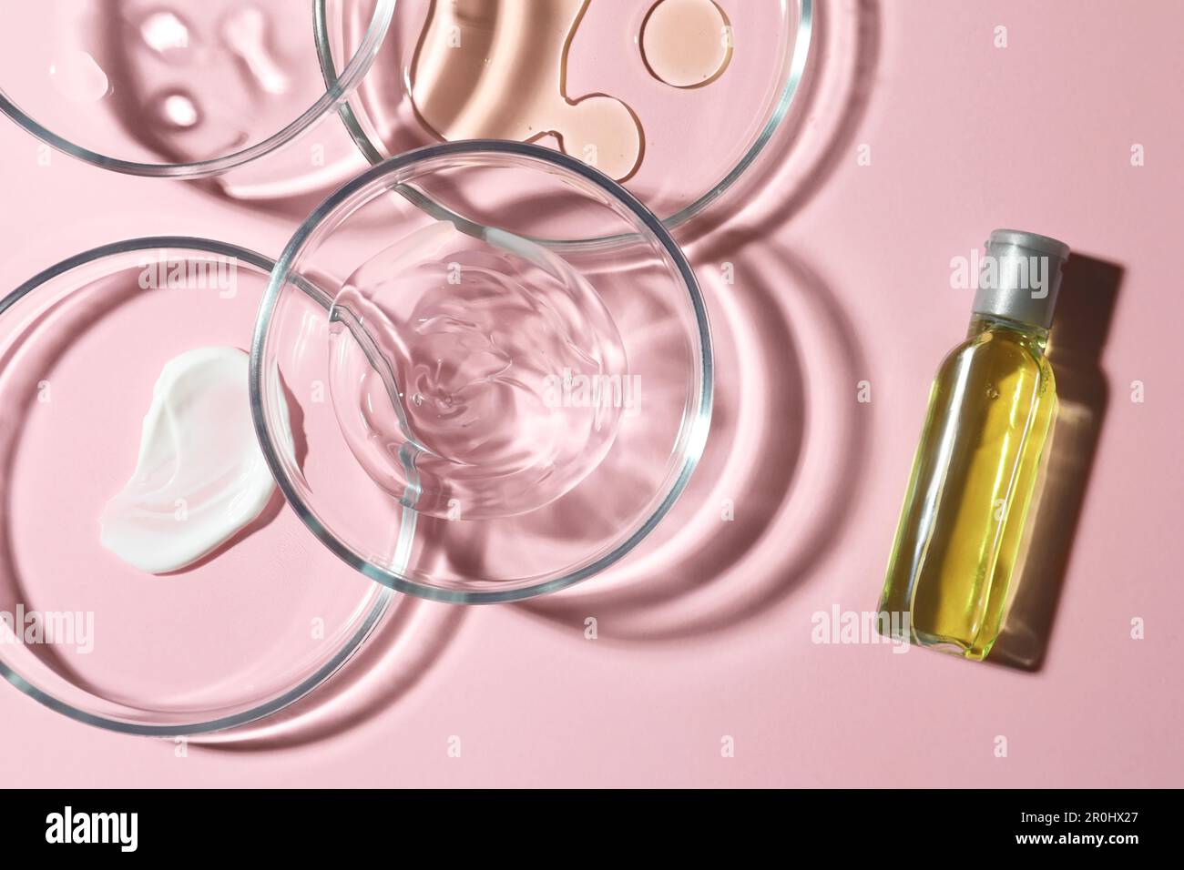 Many Petri dishes and cosmetic products on pink background, flat lay ...