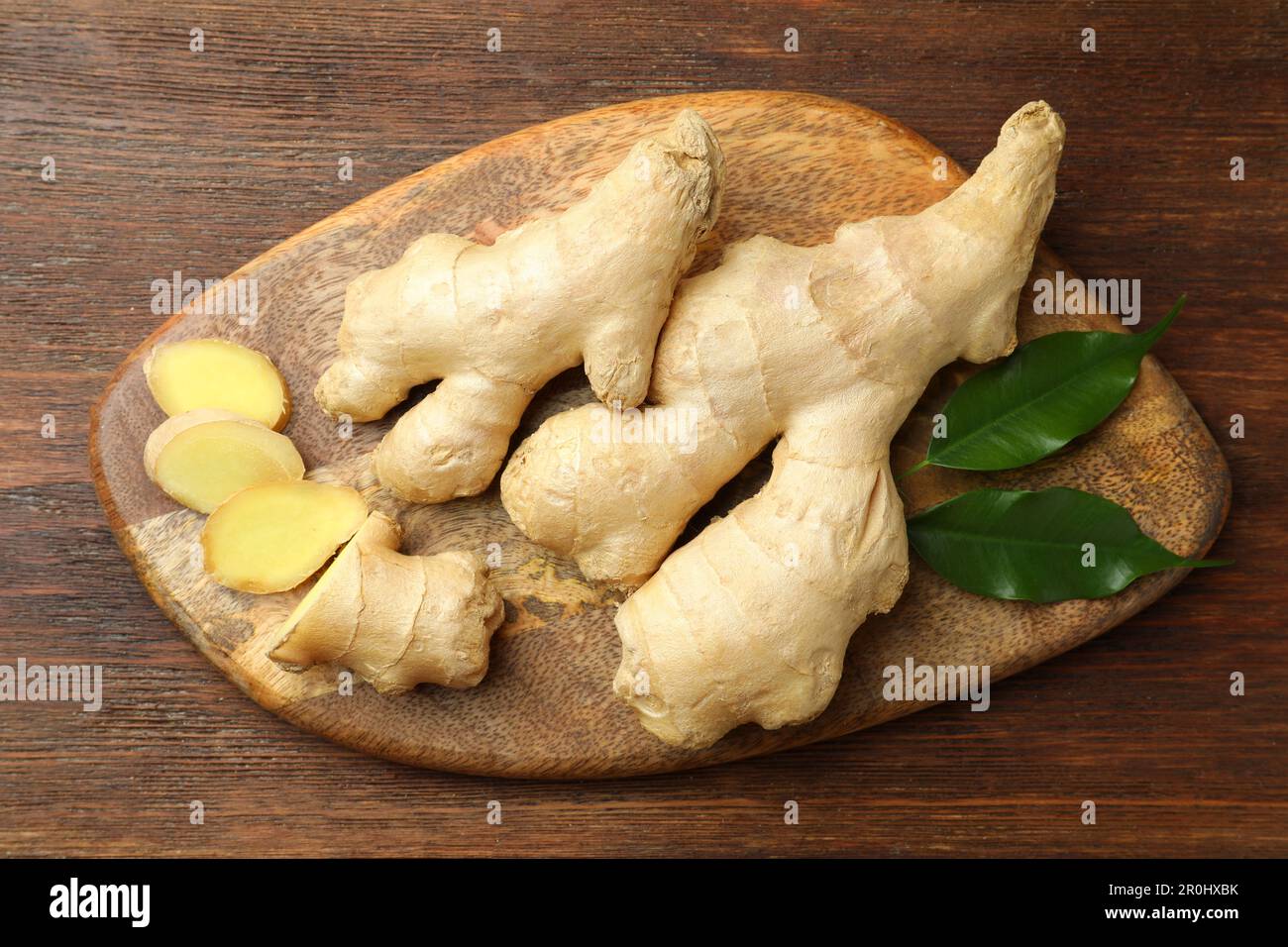 Cut and whole fresh ginger with leaves on wooden table, top view Stock ...