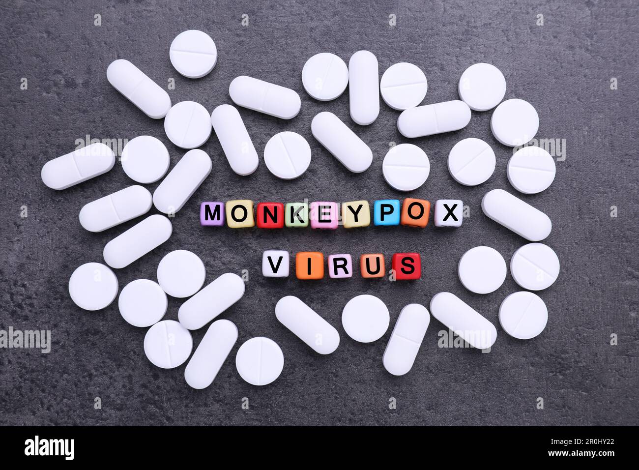 Words Monkeypox Virus made of cubes and pills on grey table, flat lay ...