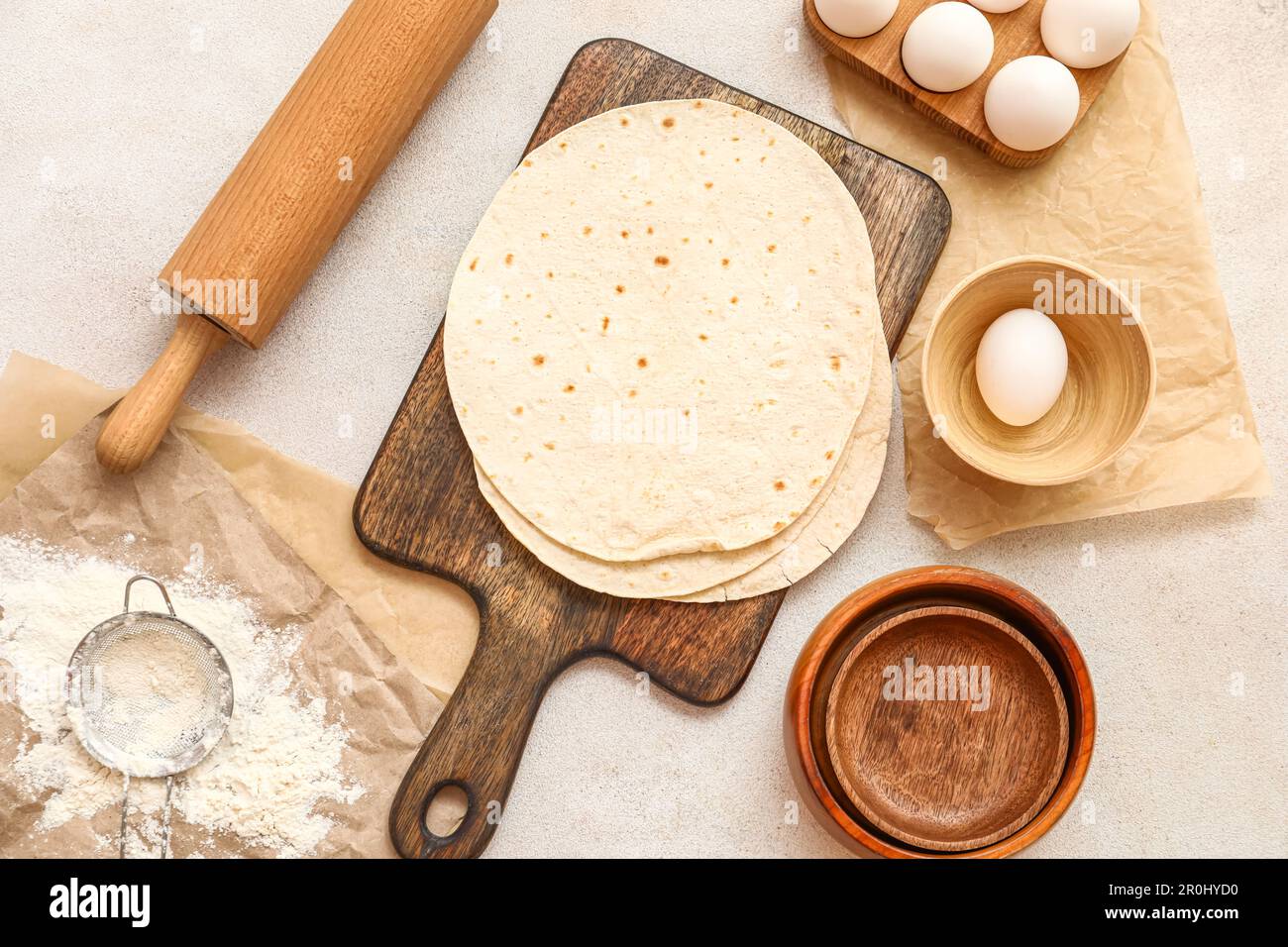 Wooden board with fresh lavash and ingredients on light background ...