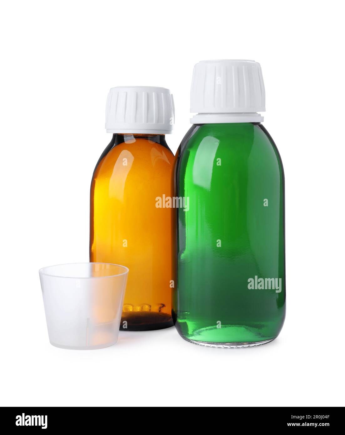 Bottles of syrups with measuring cup on white background. Cough and ...