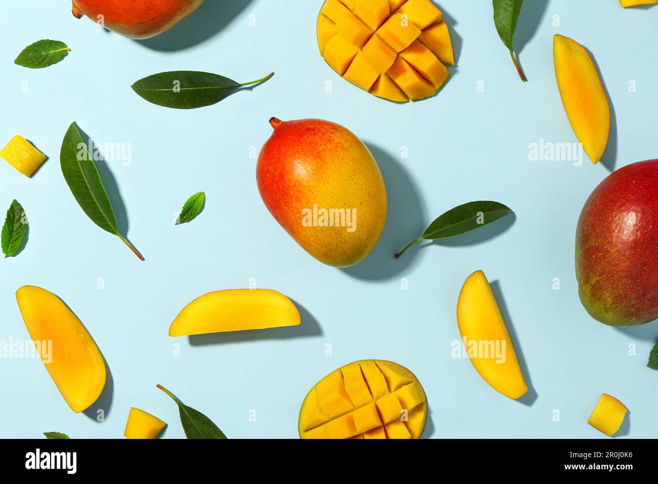 Fresh ripe mangoes on light blue background Stock Photo - Alamy