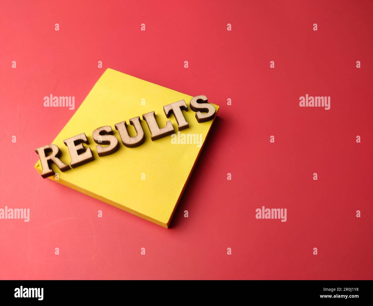 Wooden word and sticky note with the word RESULT on a red background ...