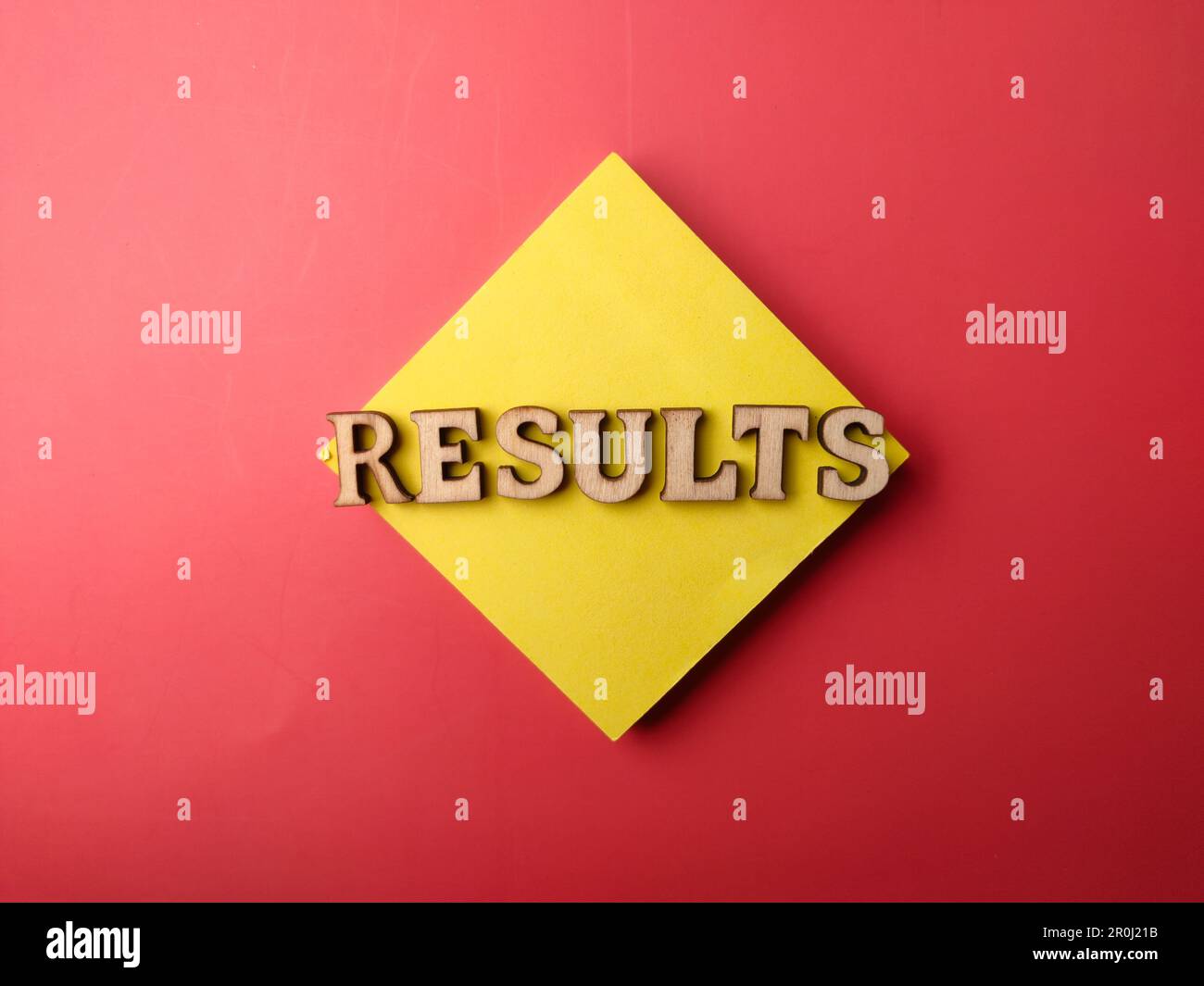 Wooden word and sticky note with the word RESULT on a red background ...