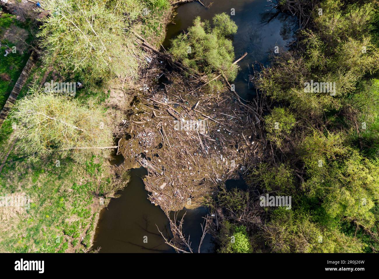 Aerial view of a floating pile of twigs and plastic trash in a river ...