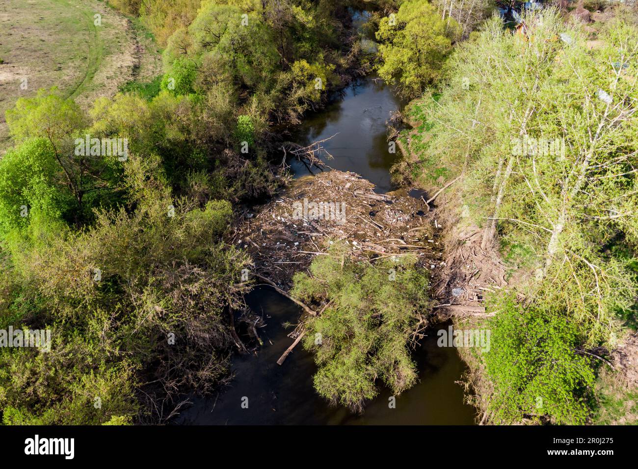 Aerial view of a floating pile of twigs and plastic trash in a river ...