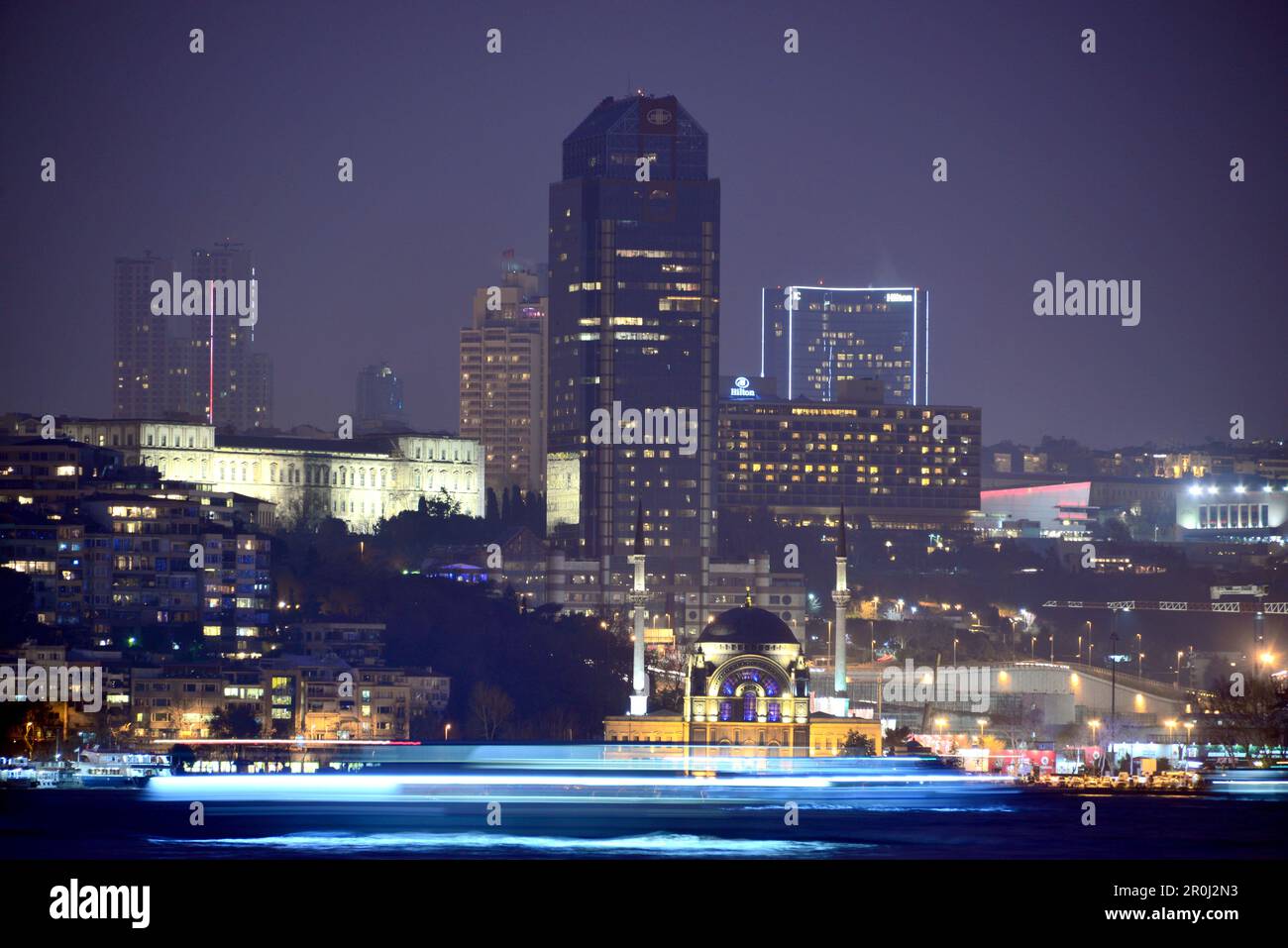 View over the Bosphorus to Ortakoey Mosque with high-rise buildings in ...