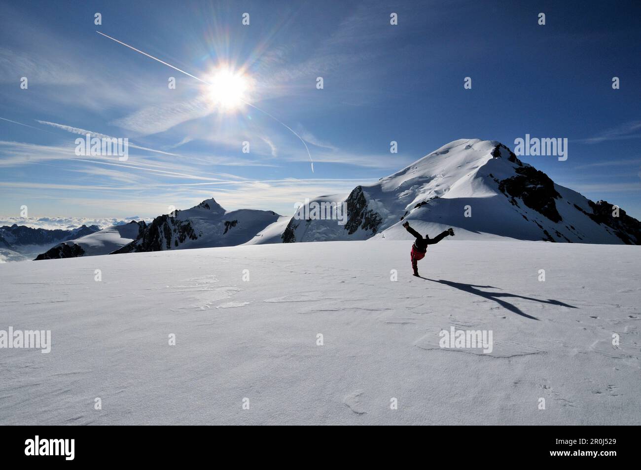 Mountaineer is doing a headstand on the summit of Dome de Gouter, Mont ...