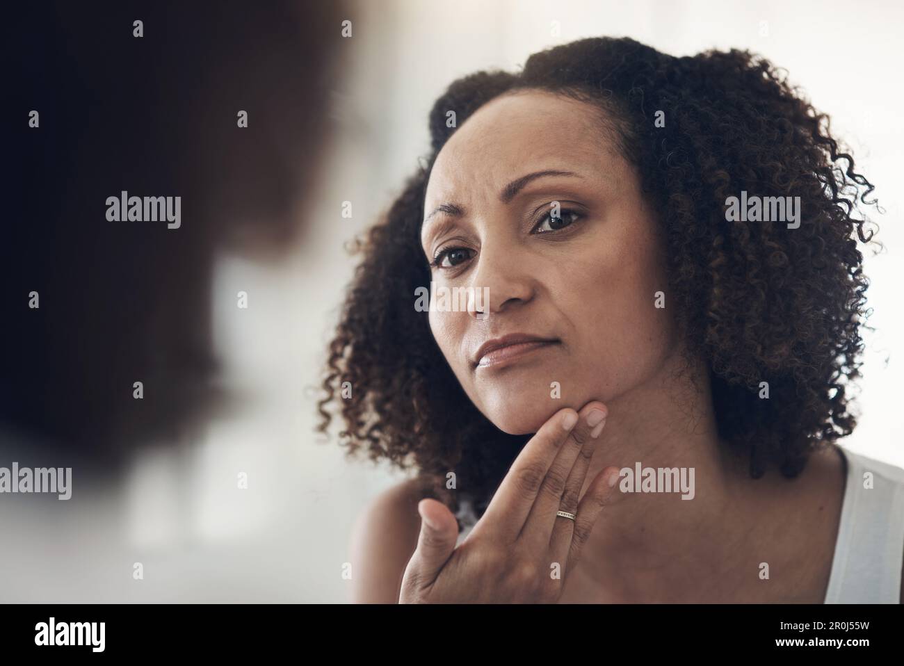 Is that a rash. an attractive young woman standing in her bathroom at ...