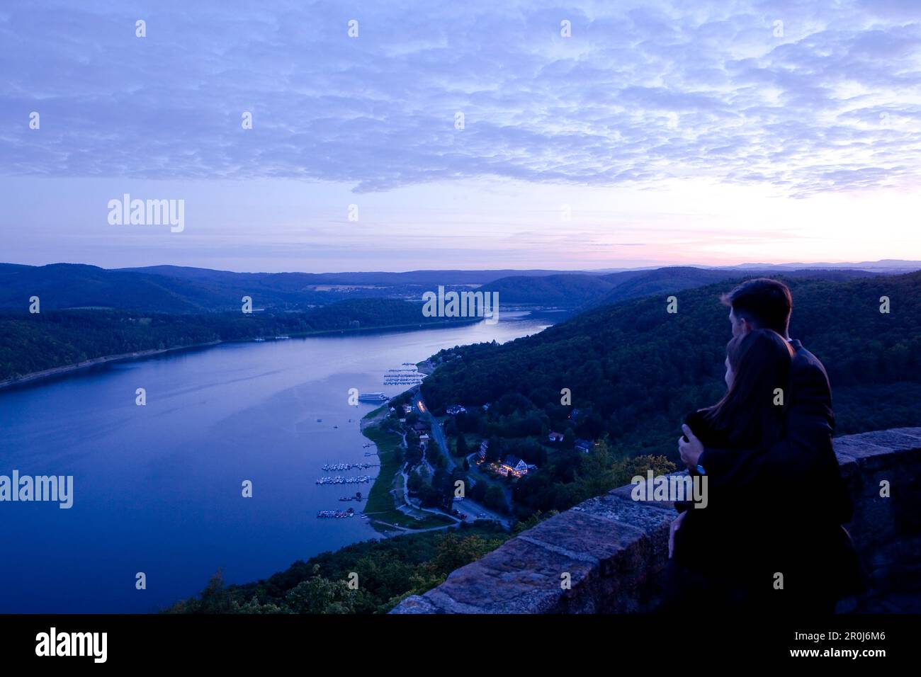 A couple admires Lake Edersee in Kellerwald-Edersee National Park from ...
