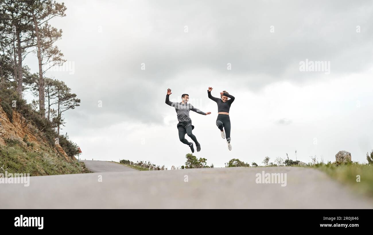 We did it. Full length shot of two young athletes jumping for joy after ...