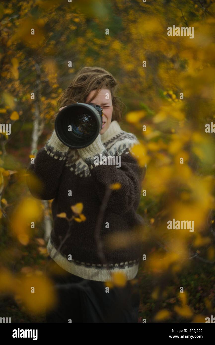Caucasian female photographer using camera with telephoto lens in ...