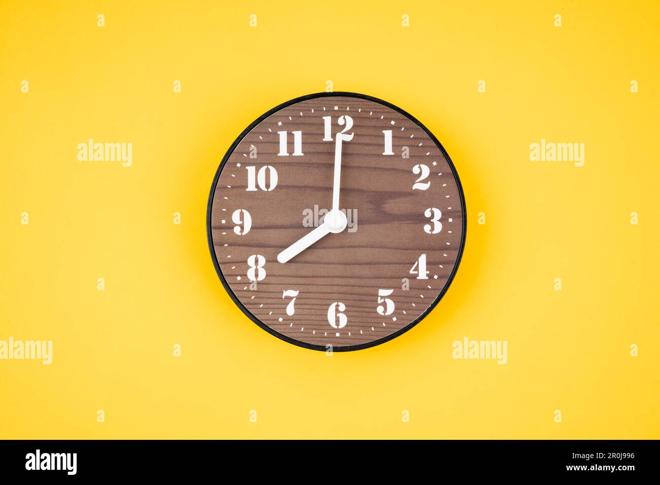 Retro wooden clock at 8 O' clock on yellow color background Stock Photo ...
