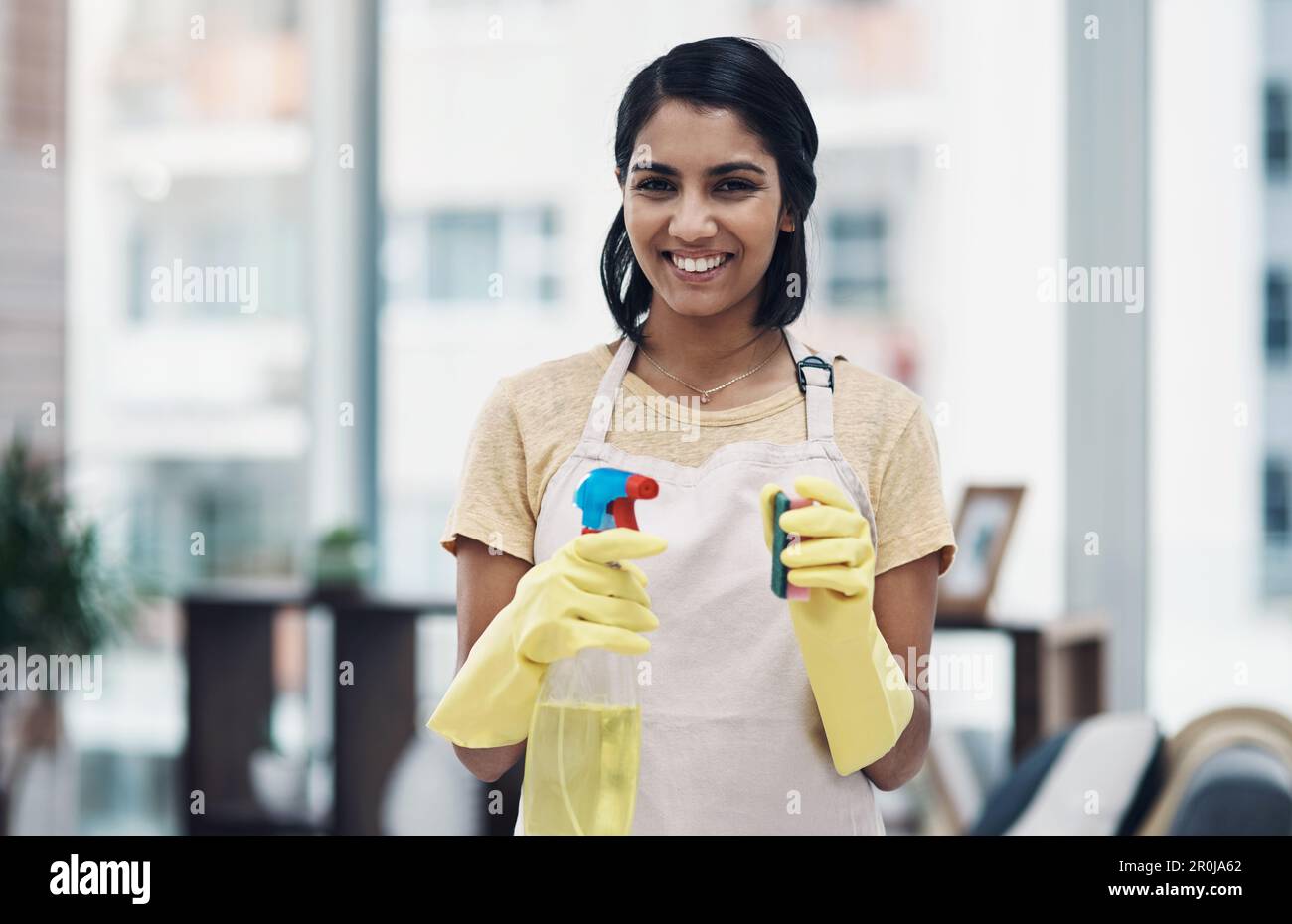 Just call me the queen of clean. a young woman using rubber gloves and ...