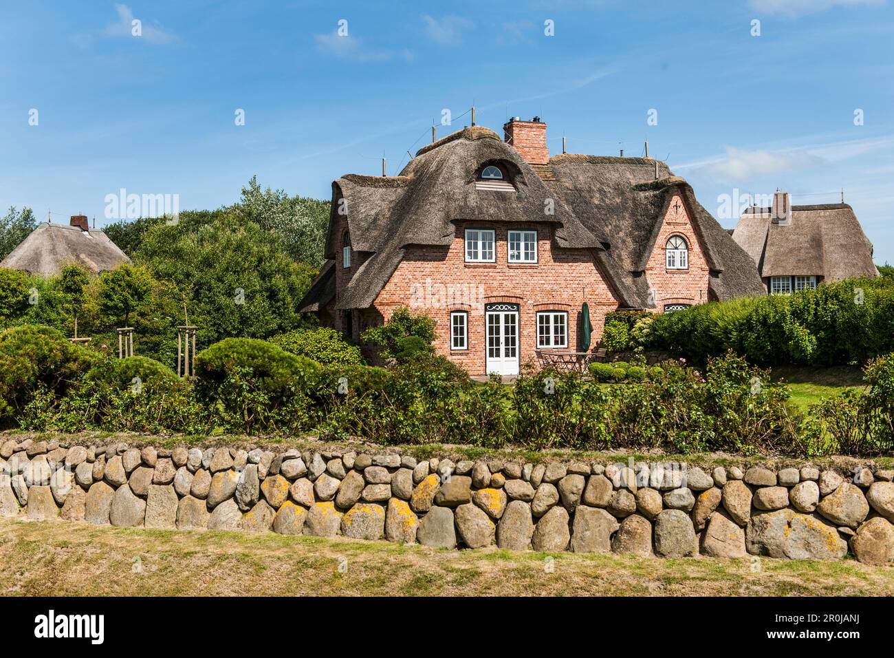 Thatched-roof house surrounded by natural stone wall, Sylt, Schleswig ...