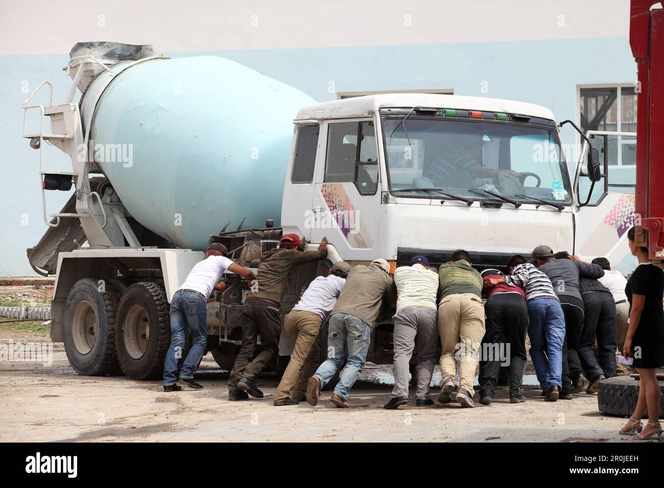 Workers pushing broken transit-truck mixer, Ulaanbaatar, Mongolia Stock ...