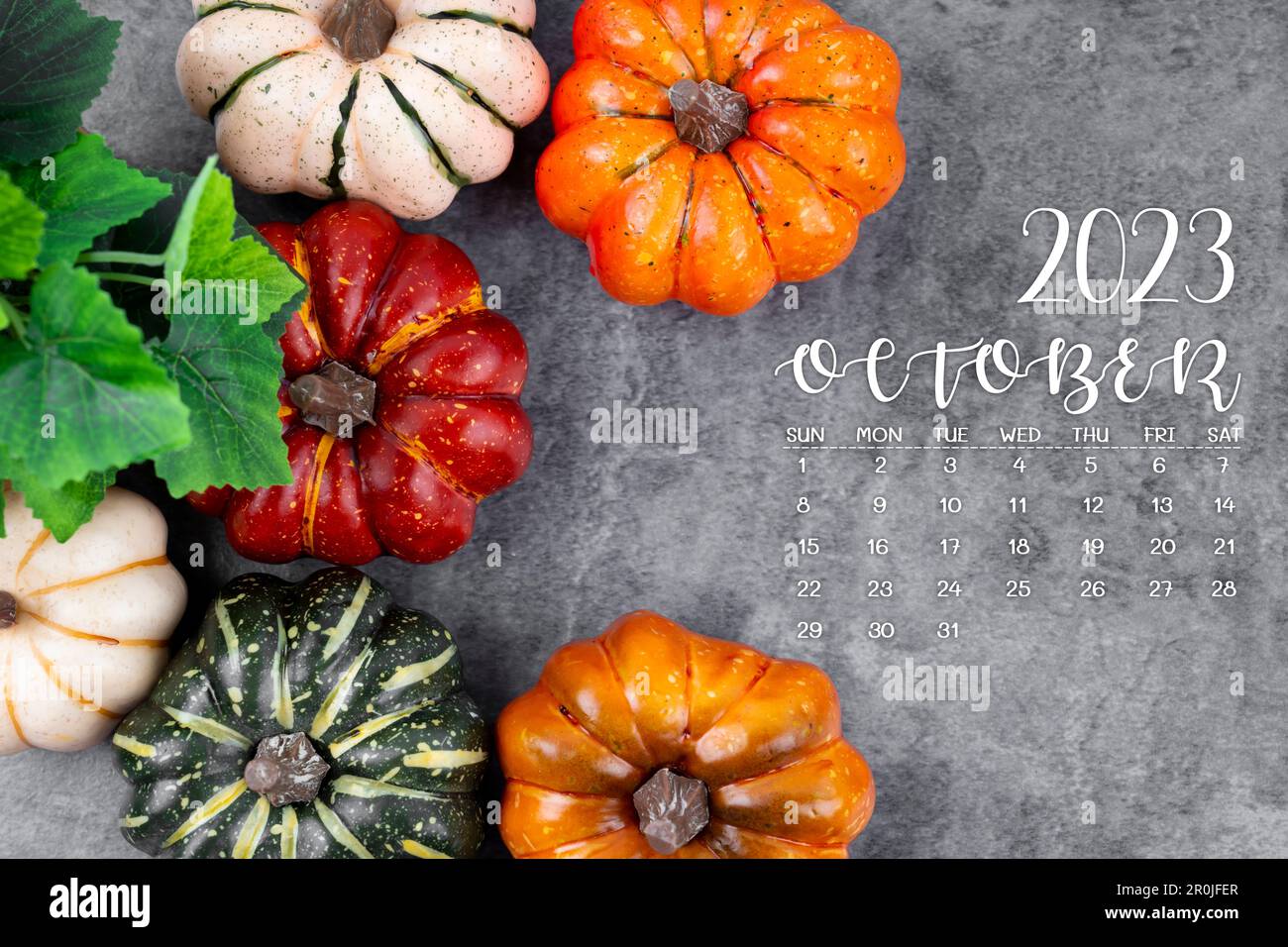 October 2023 Calendar and pumpkins with autuma leaf on old wood ...