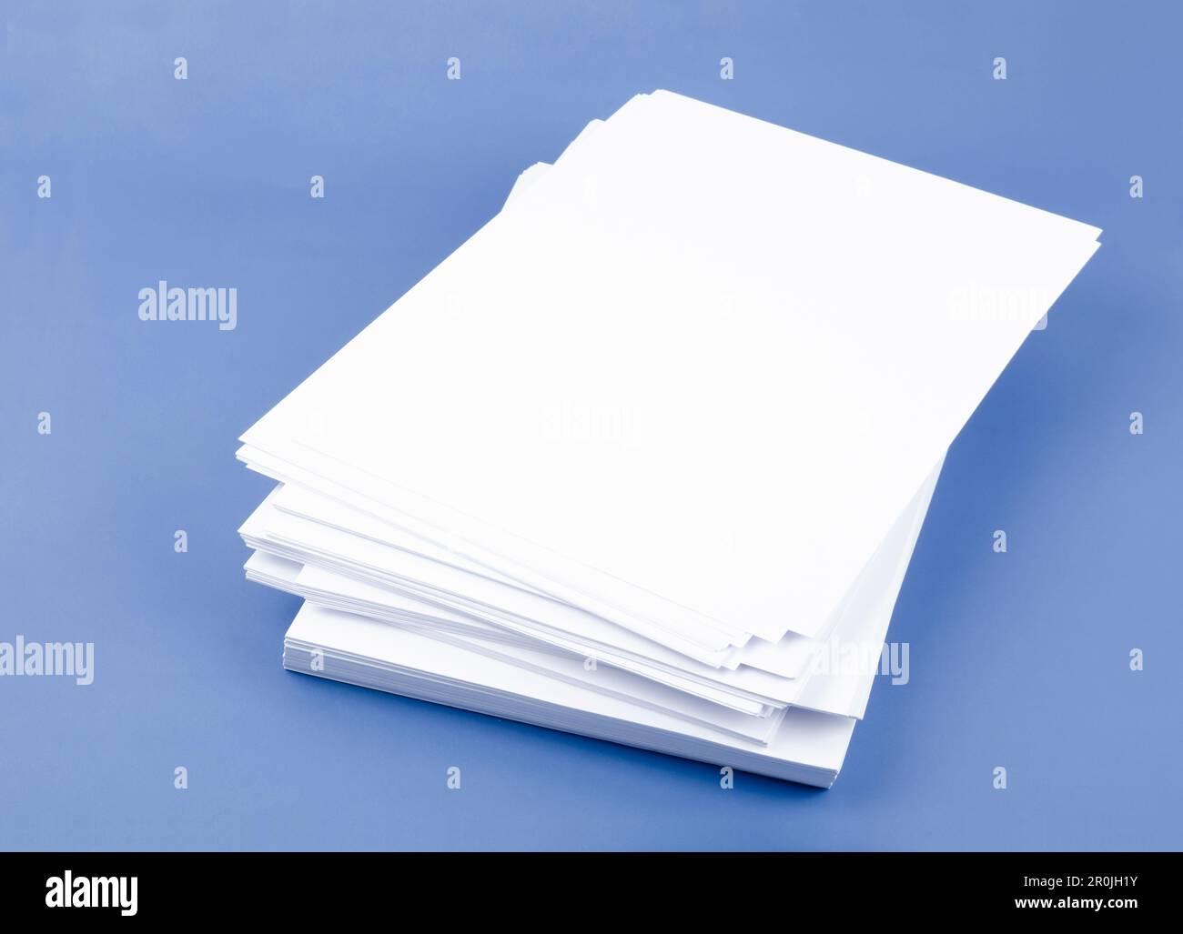 Stack of blank A4 paper sheets on blue background Stock Photo - Alamy
