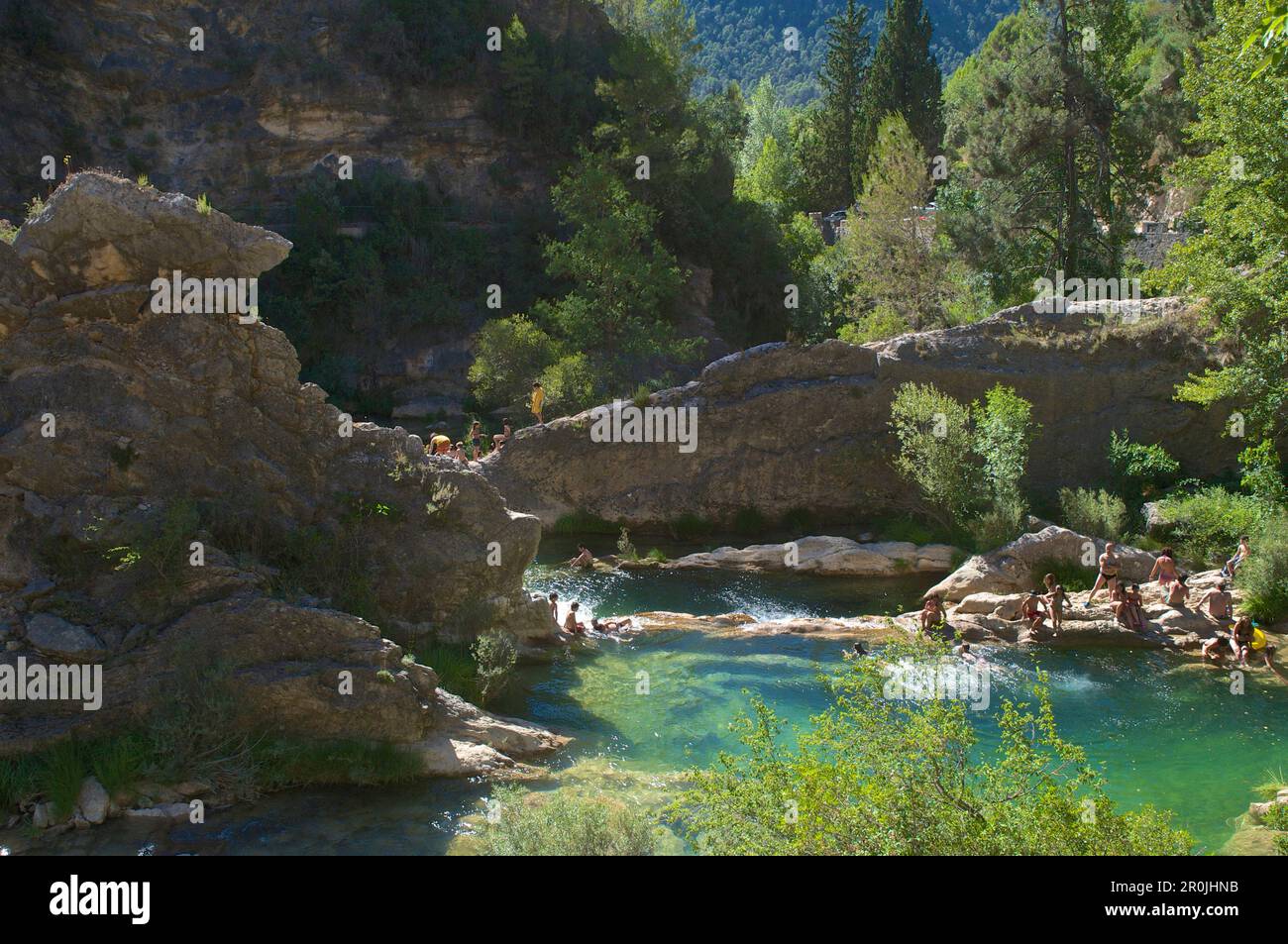 People bathing in rocky pools in the upper river of Rio Borosa, Sierras ...