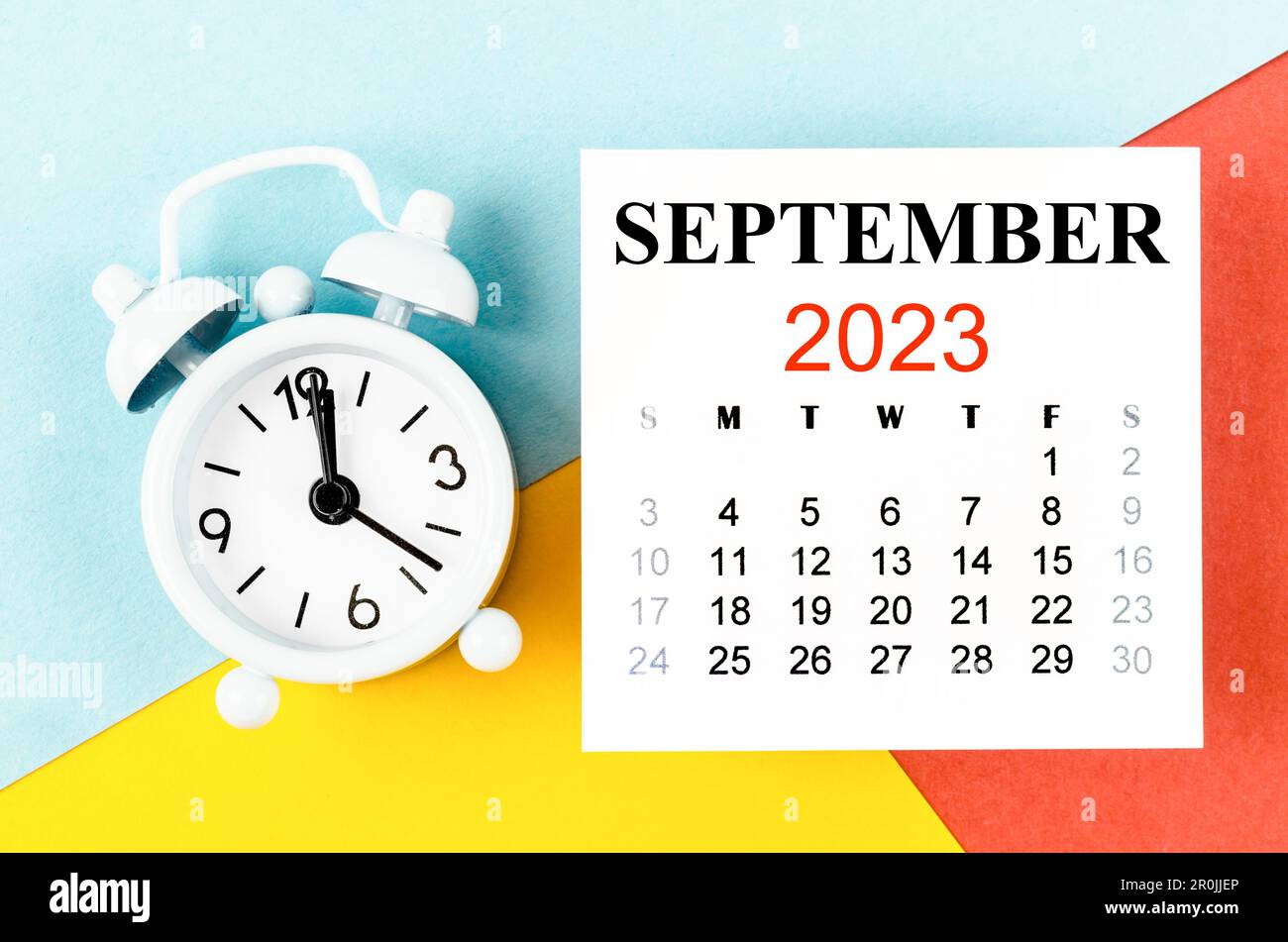September 2023 Monthly calendar year with alarm clock on colourful ...
