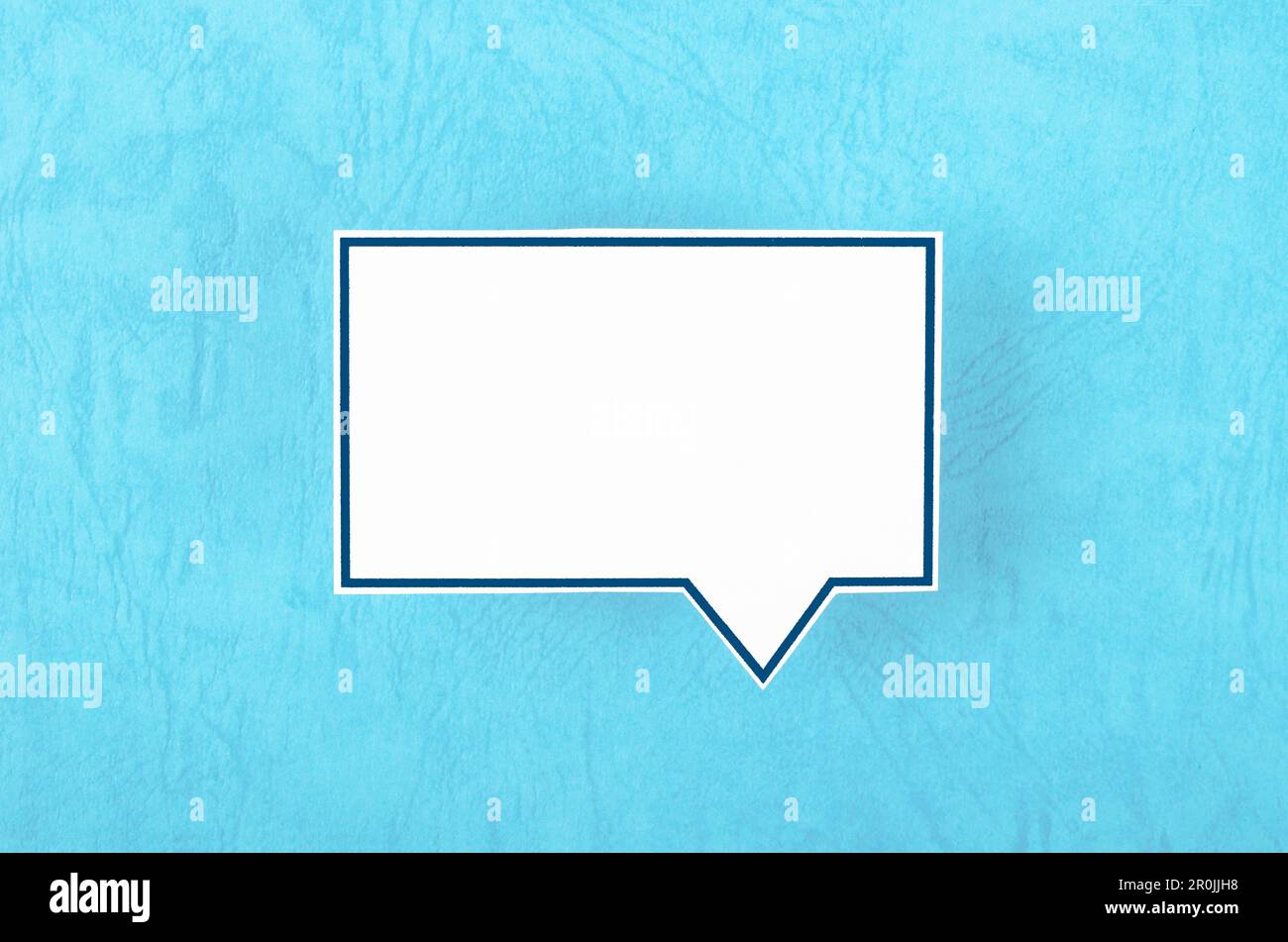 White speech bubble shaped post it note on light blue background with ...