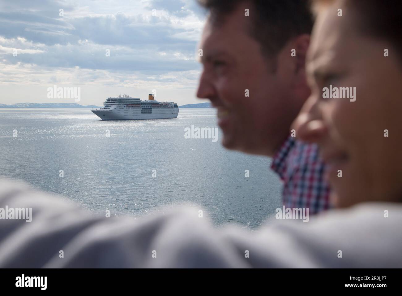 Couple at railing of cruise ship with cruise ship Costa Neo Romantica ...