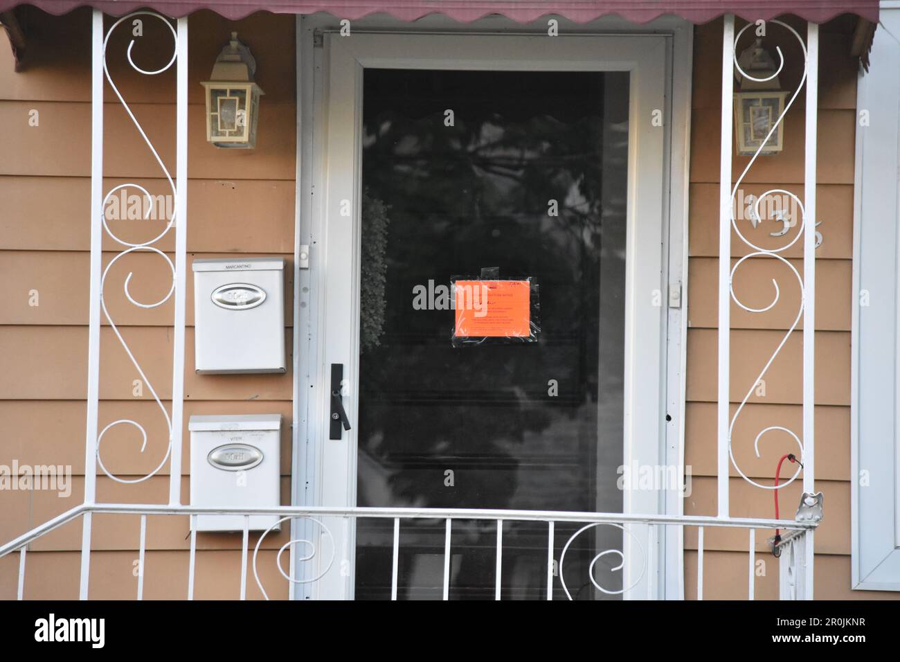 Orange sticker is put on the front door of the house warning people not ...