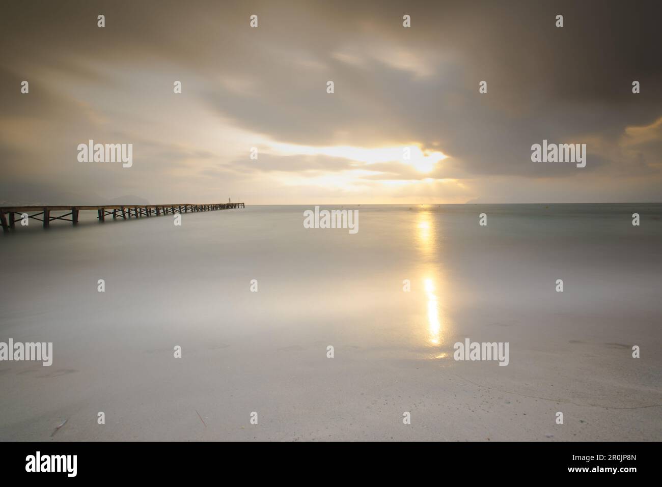 Long exposure of a wooden pier on Playa de Muro beach in the morning ...