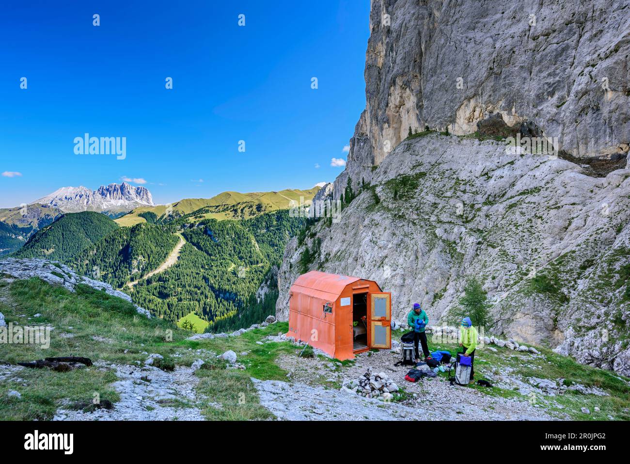 Two persons standing in front of bivouac Zeni, Langkofel in background ...